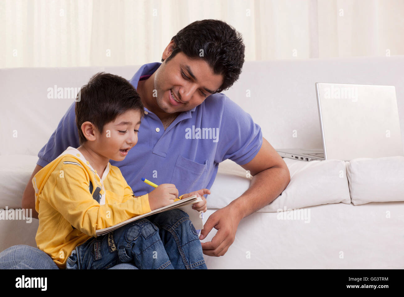 Happy young father helping his son in drawing at home Stock Photo - Alamy