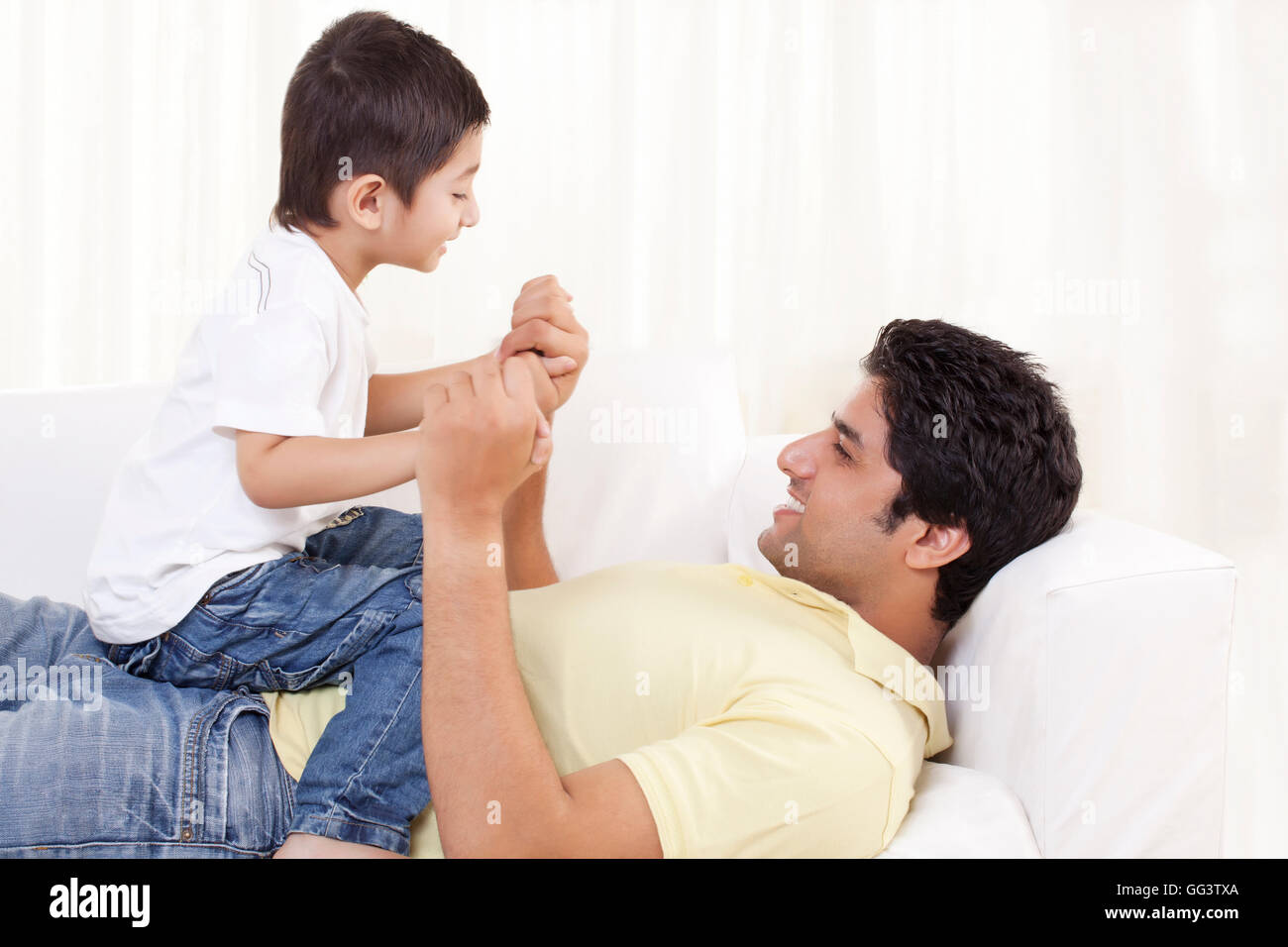 Cute little boy sitting on father Stock Photo - Alamy
