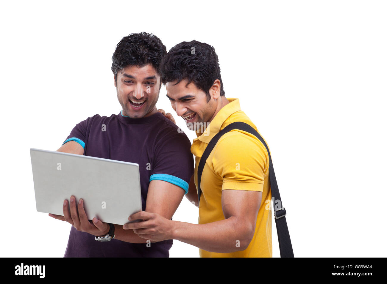 Male friends laughing while using laptop Stock Photo - Alamy