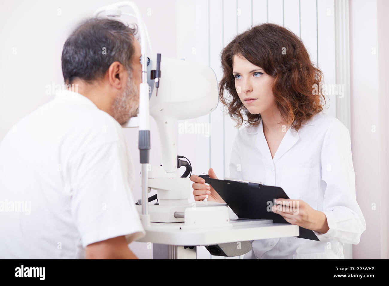 pretty young optometrist at work, examinating your eyes Stock Photo - Alamy