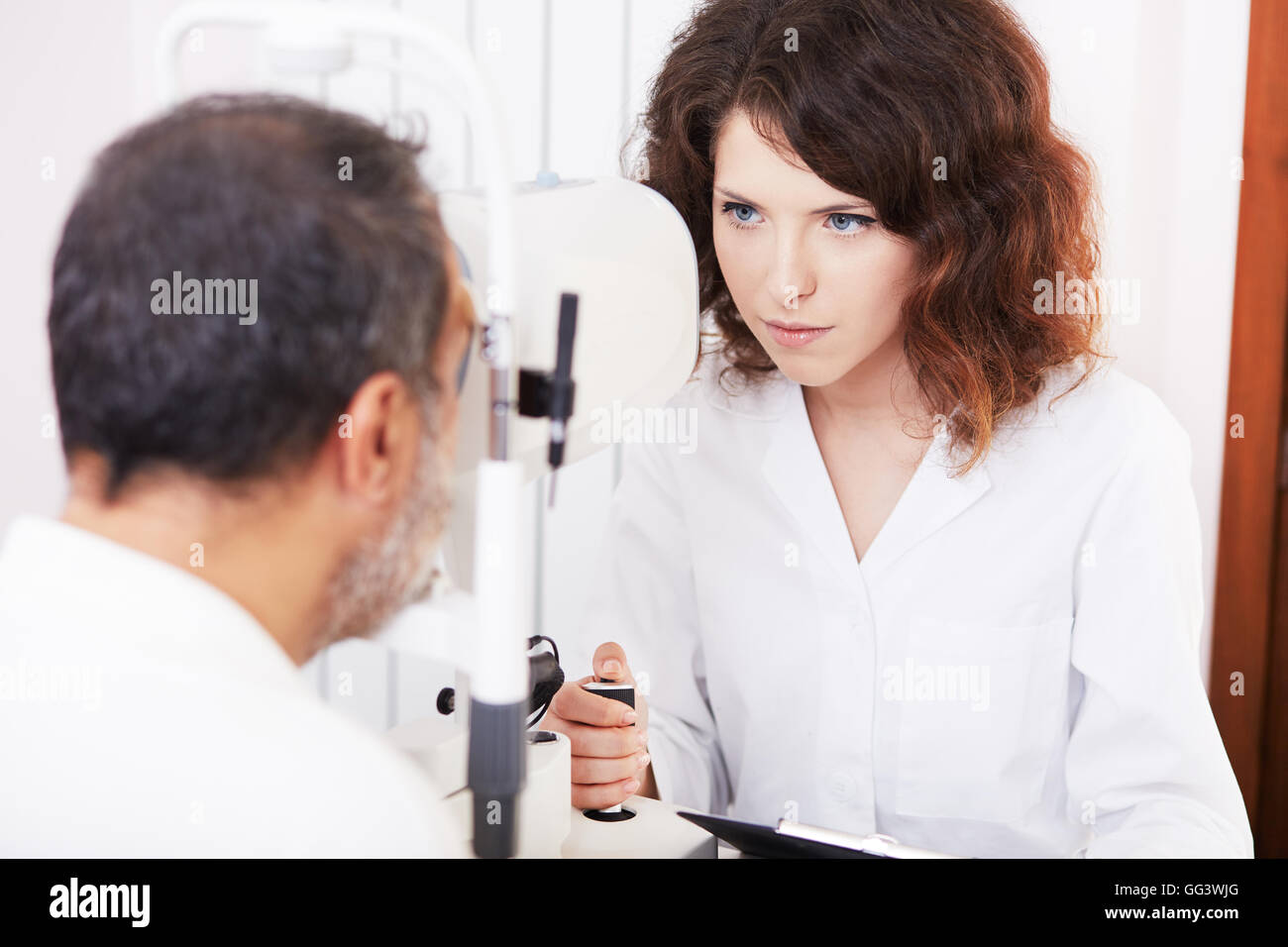 pretty young optometrist at work, examinating your eyes Stock Photo - Alamy