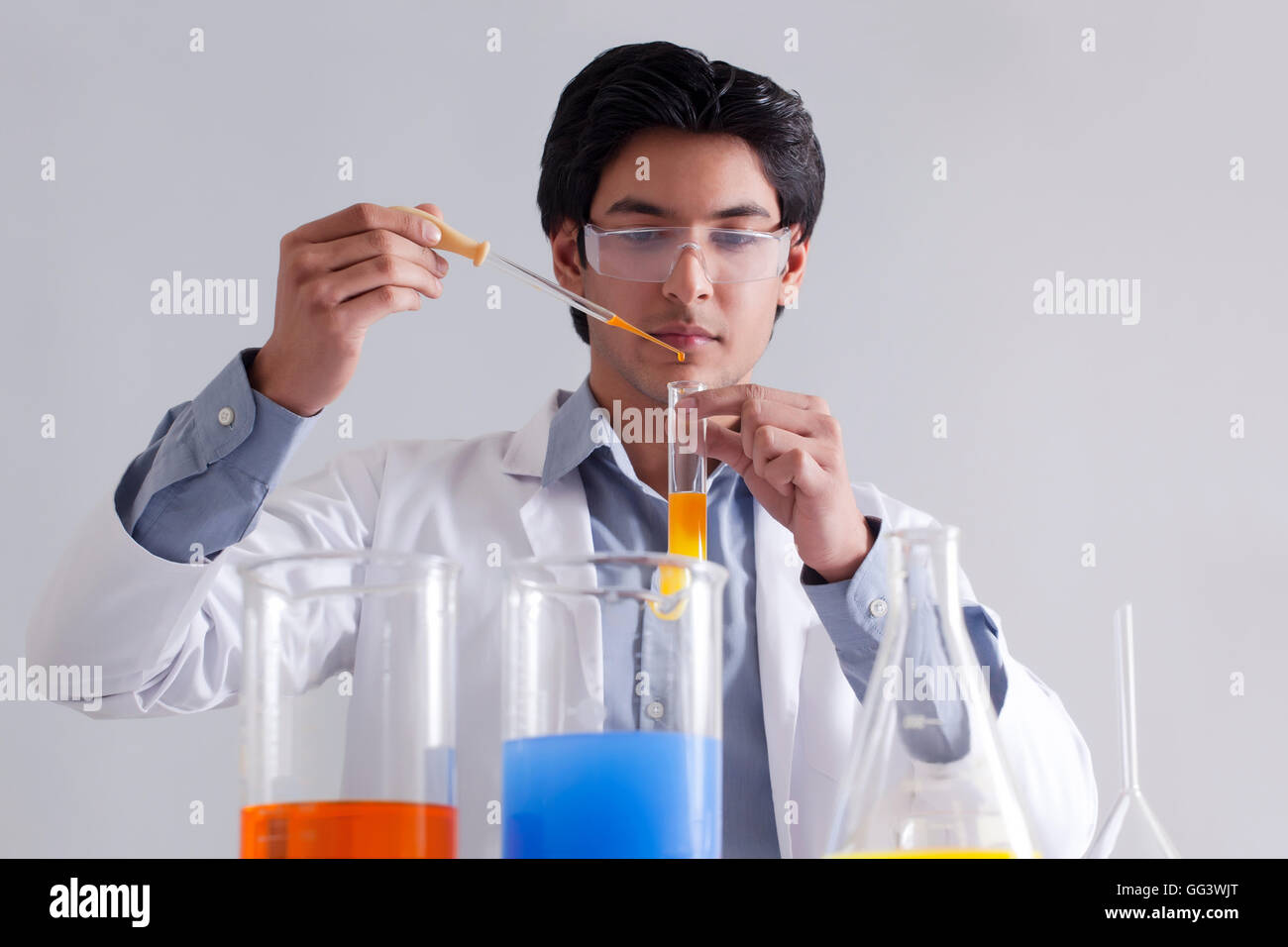 Lab technician adding solution to test tube Stock Photo - Alamy