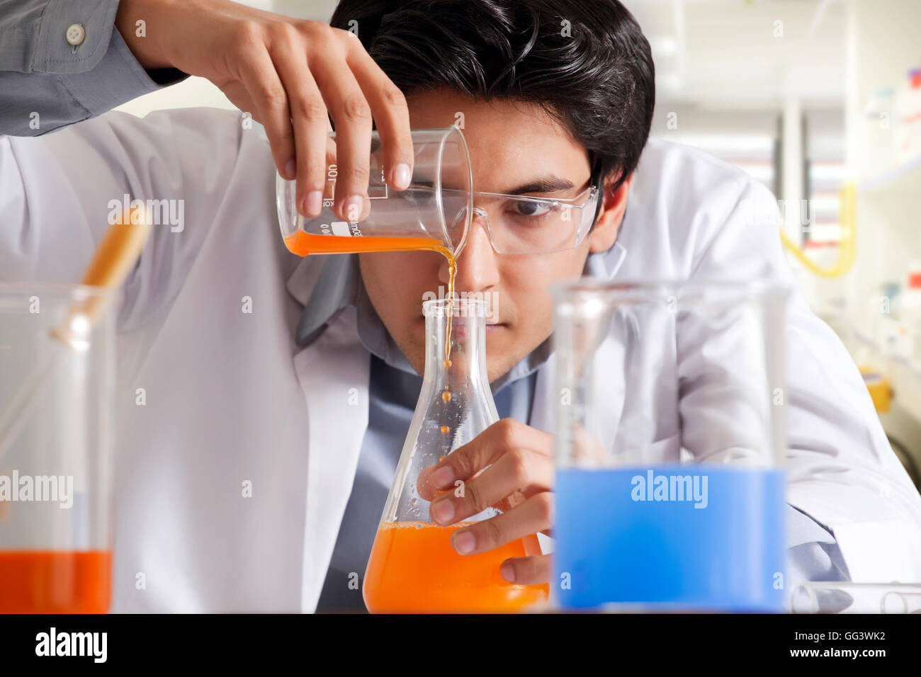 Man pouring liquid into a flask Stock Photo - Alamy