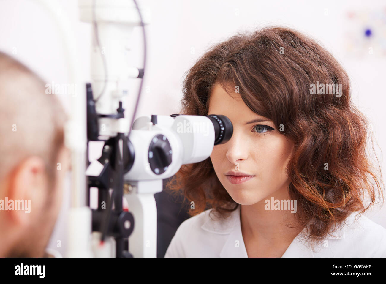 pretty young optometrist at work, examinating your eyes Stock Photo - Alamy