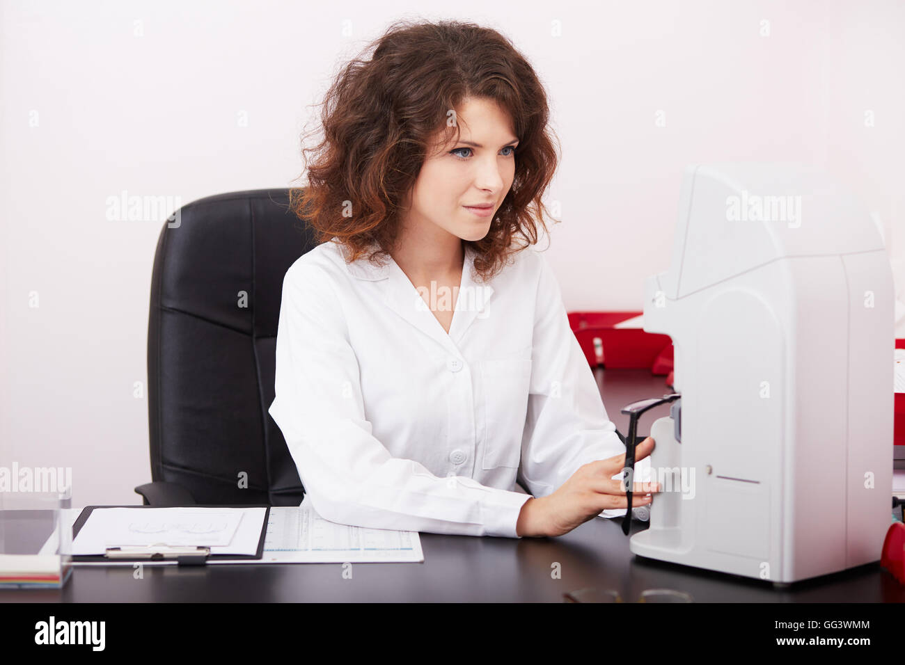 pretty young optometrist at work, examinating your eyes Stock Photo - Alamy