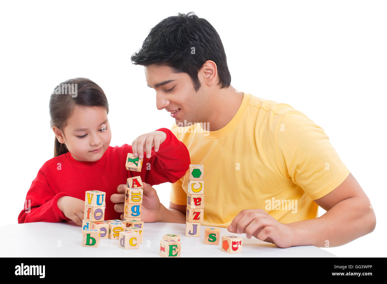 Father assisting girl in playing block game Stock Photo - Alamy