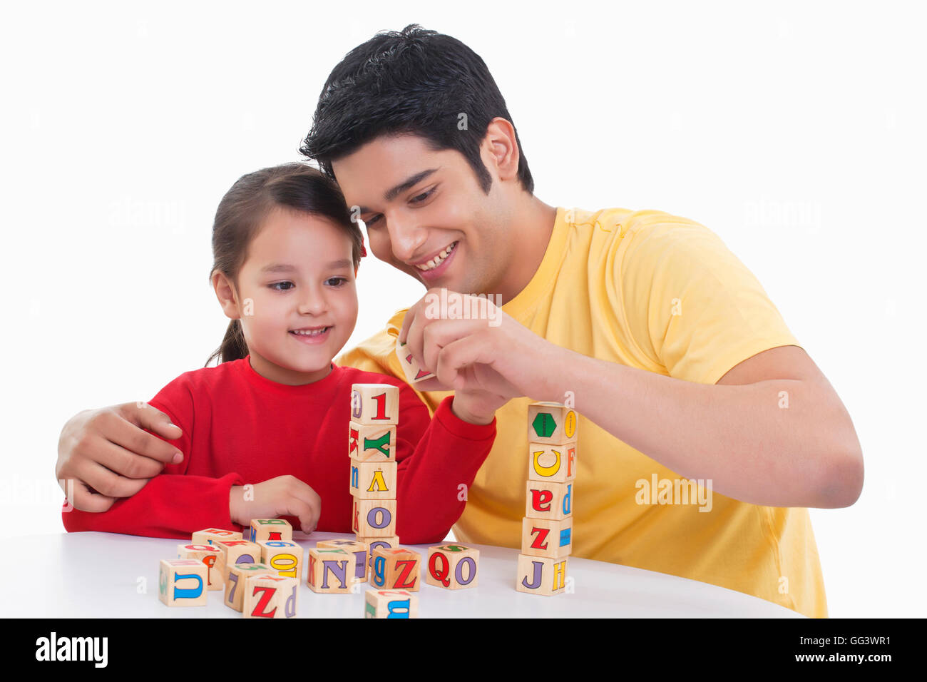 Smiling father assisting girl in playing block game Stock Photo - Alamy