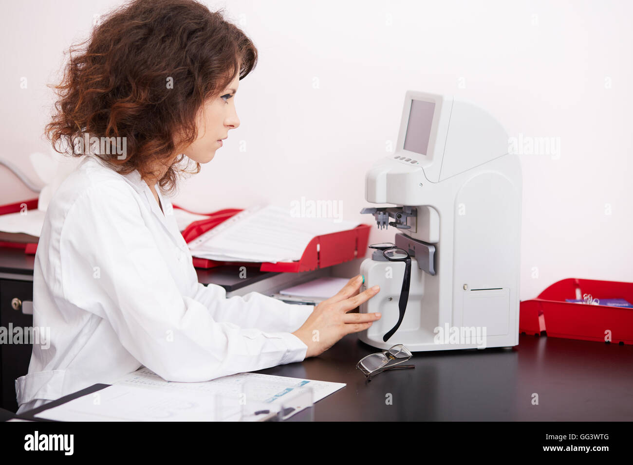 pretty young optometrist at work, examinating your eyes Stock Photo - Alamy
