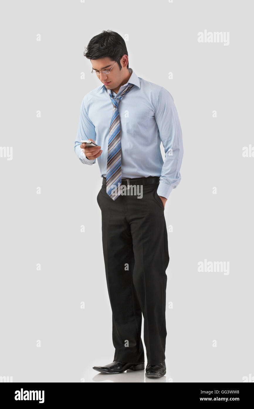 Smart young businessman texting over colored background Stock Photo - Alamy