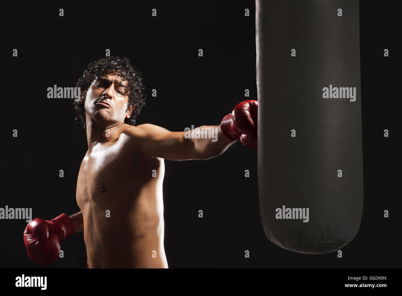 Male boxer hitting heavy bag Stock Photo - Alamy
