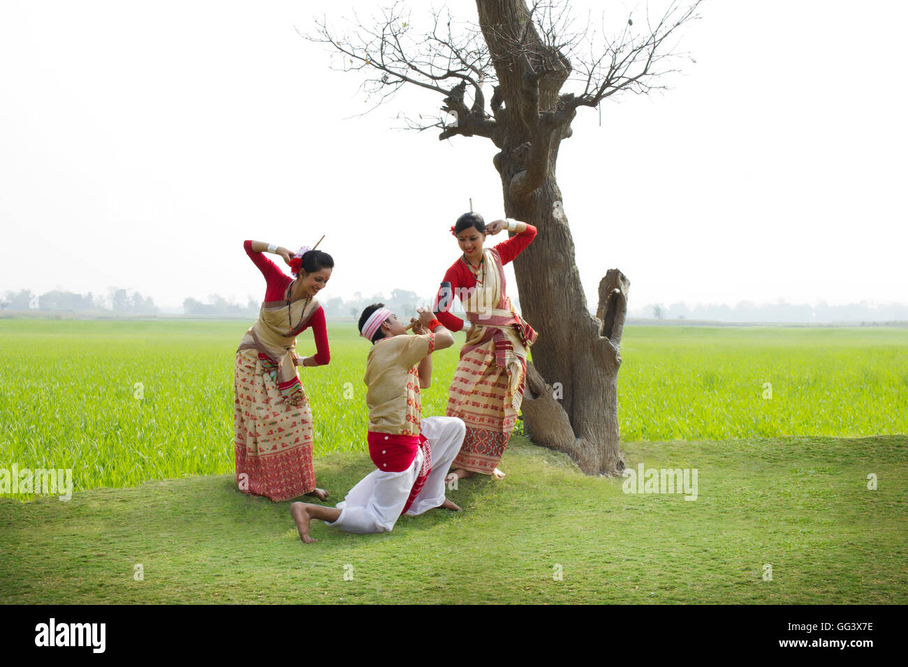 Bihu man playing on a pepa while Bihu women dance to his tune Stock ...