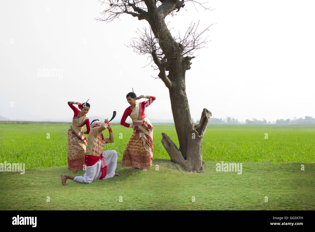 Bihu man playing on a pepa while Bihu women dance to his tune Stock ...