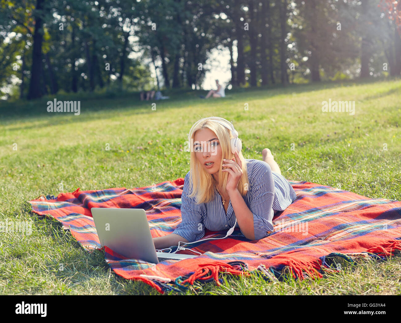Happy girl using laptop computer with headphone on the meadow Stock ...