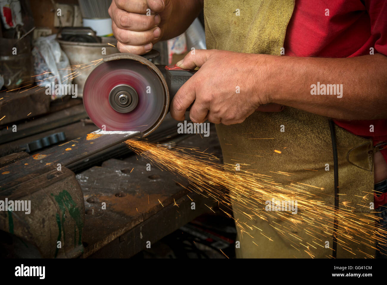 worker cutting iron plate with grinder in old metal workshop Stock ...