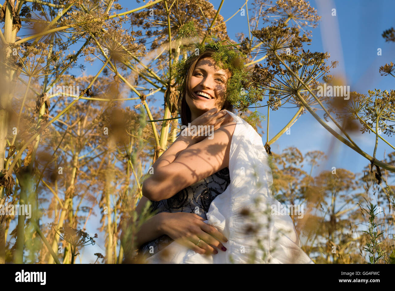 portrait of pretty young woman in field with high grass enjoing nature ...