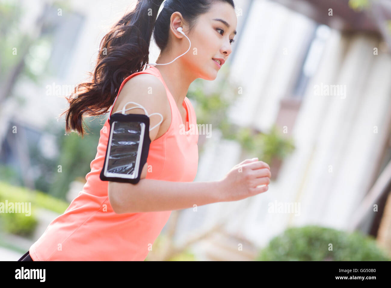 Young Chinese woman jogging and listening to music Stock Photo - Alamy