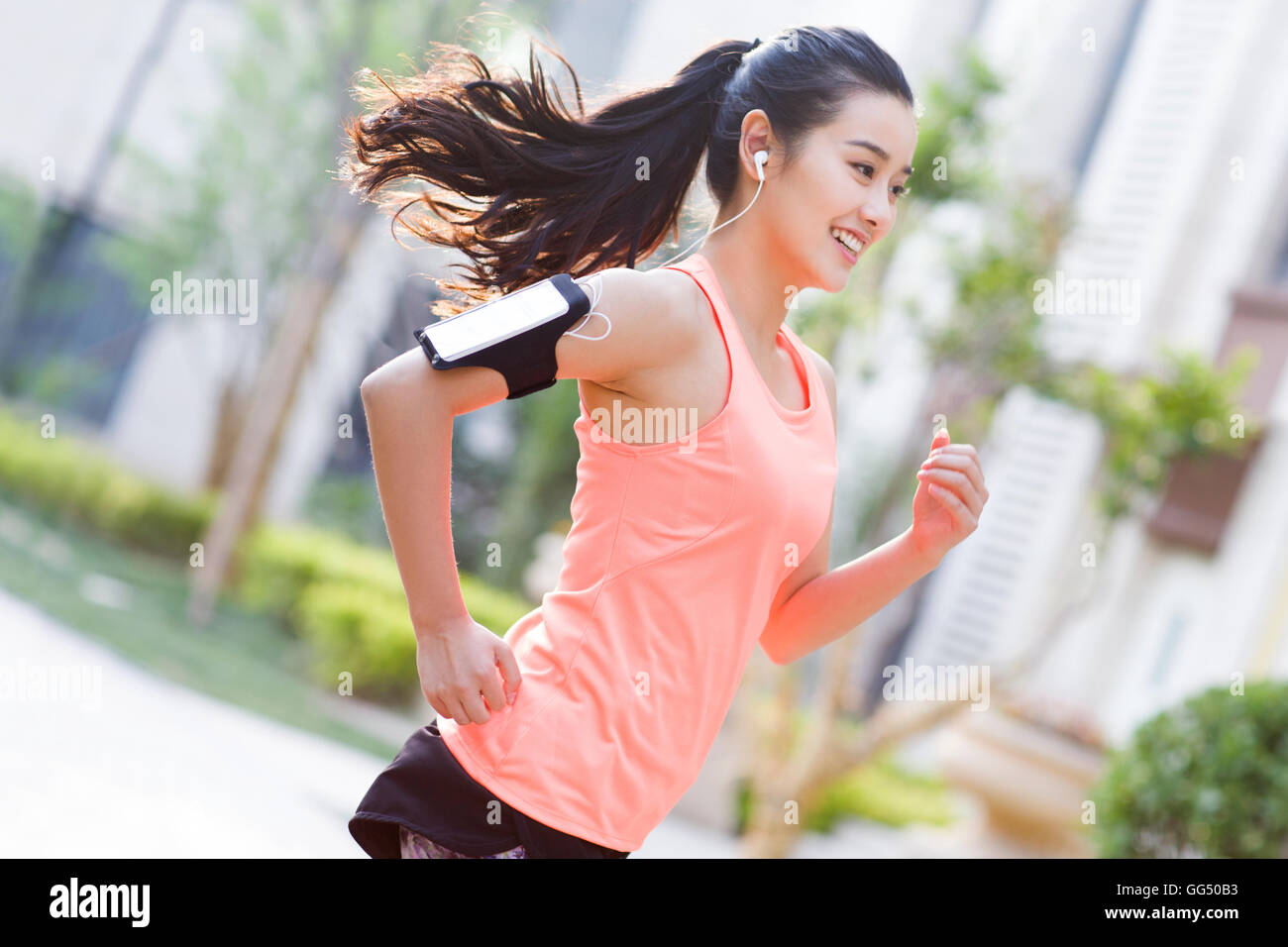 Young Chinese woman jogging and listening to music Stock Photo - Alamy