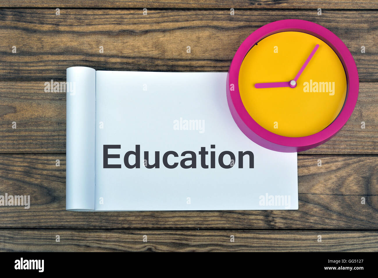 Clock and word Education on wooden table Stock Photo - Alamy