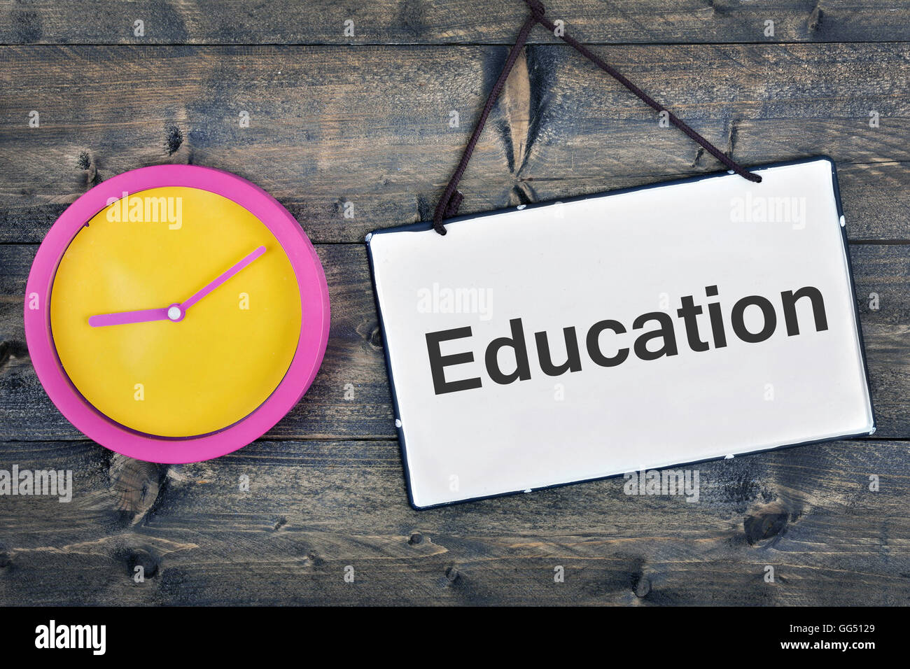 Education sign and clock on wooden table Stock Photo - Alamy