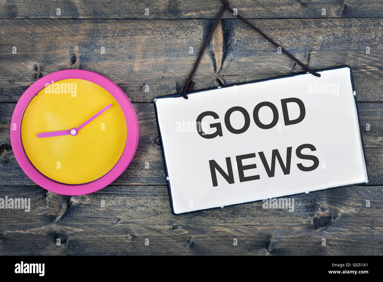 Good news sign and clock on wooden table Stock Photo - Alamy