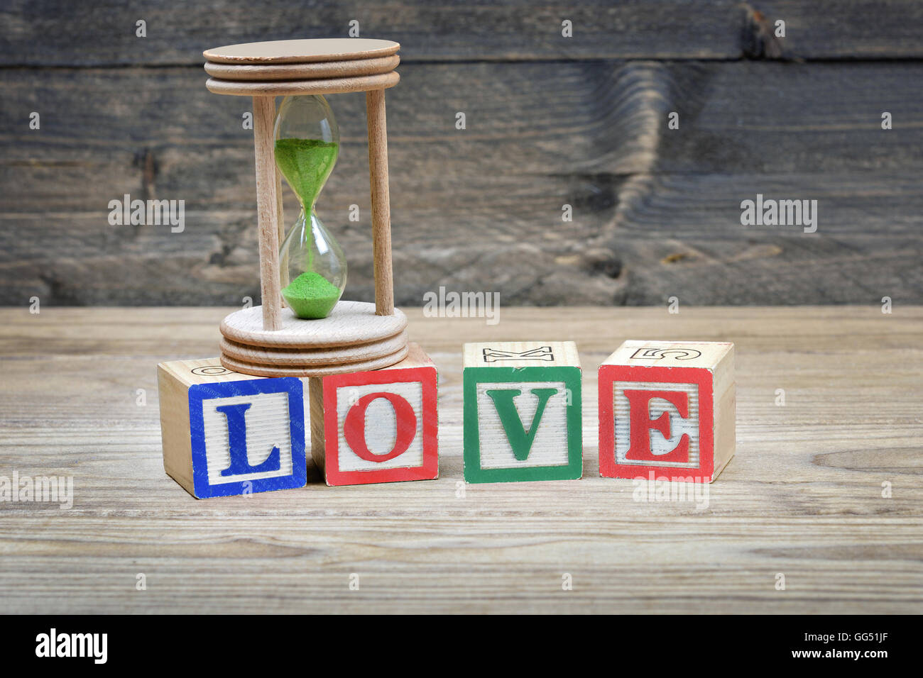 Hourglass and word love on wooden table Stock Photo - Alamy