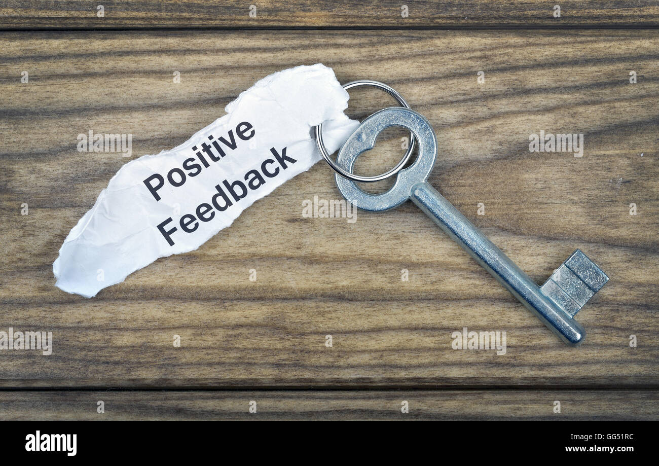 Key with message Positive Feedback on wooden table Stock Photo - Alamy
