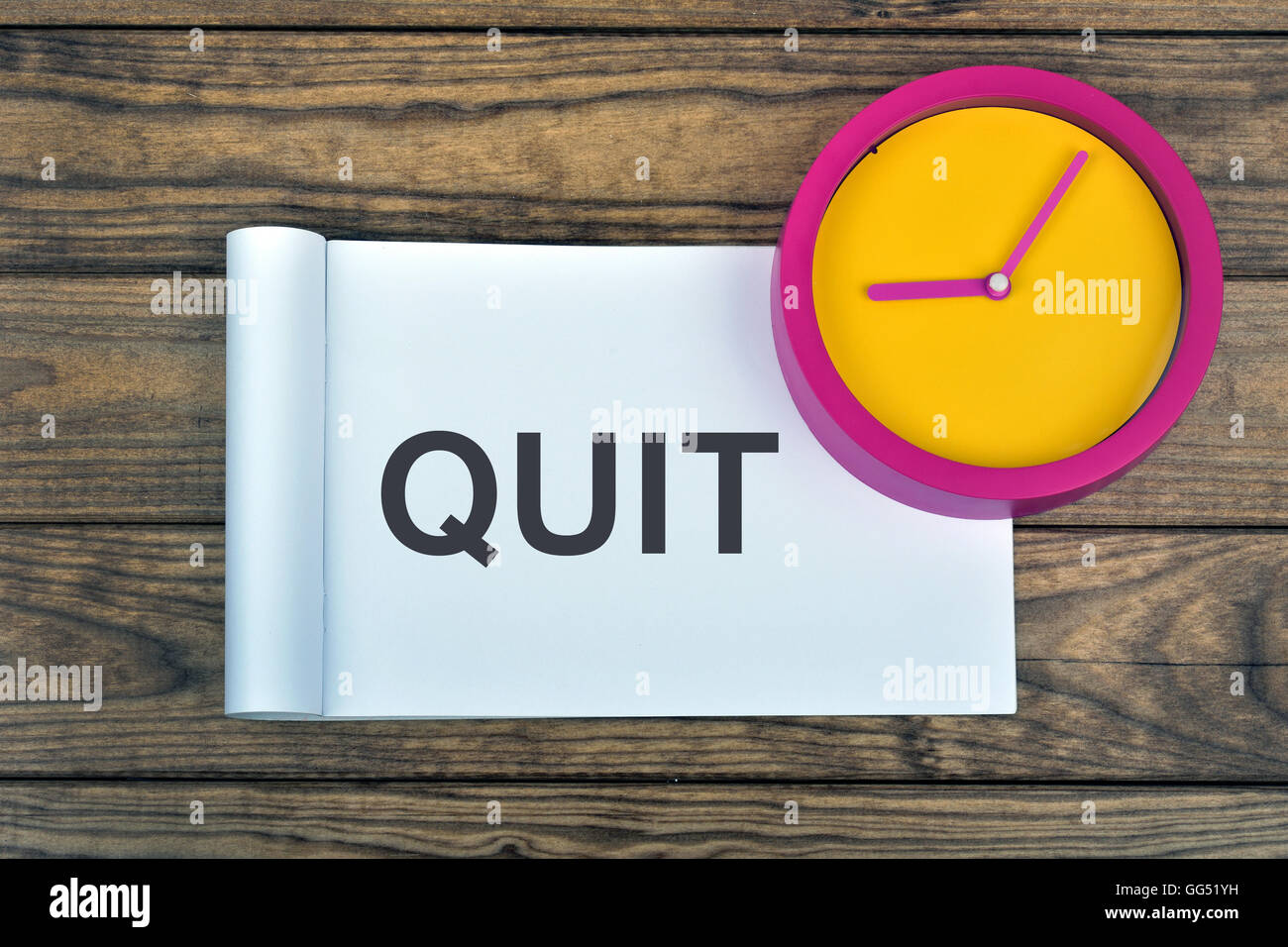 Clock and word Quit on wooden table Stock Photo - Alamy