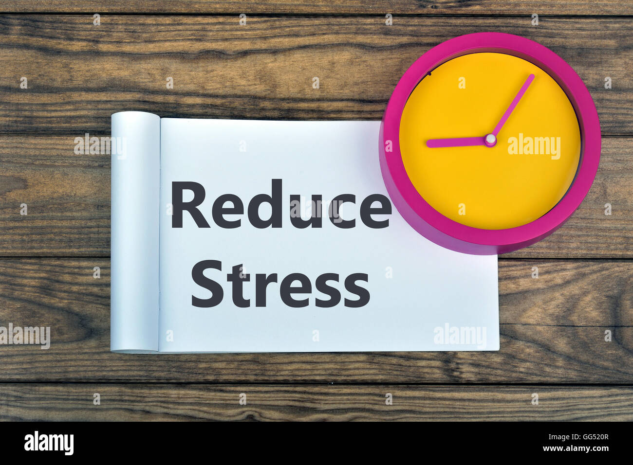 Clock and word Reduce Stress on wooden table Stock Photo - Alamy