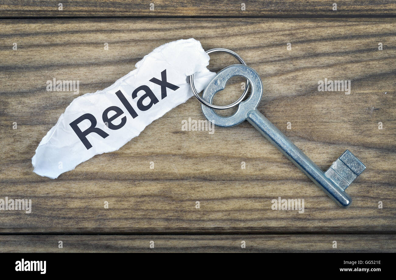 Key with message Relax on wooden table Stock Photo - Alamy