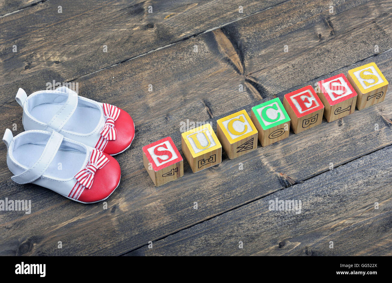 Kid shoes and word success on wooden table Stock Photo - Alamy