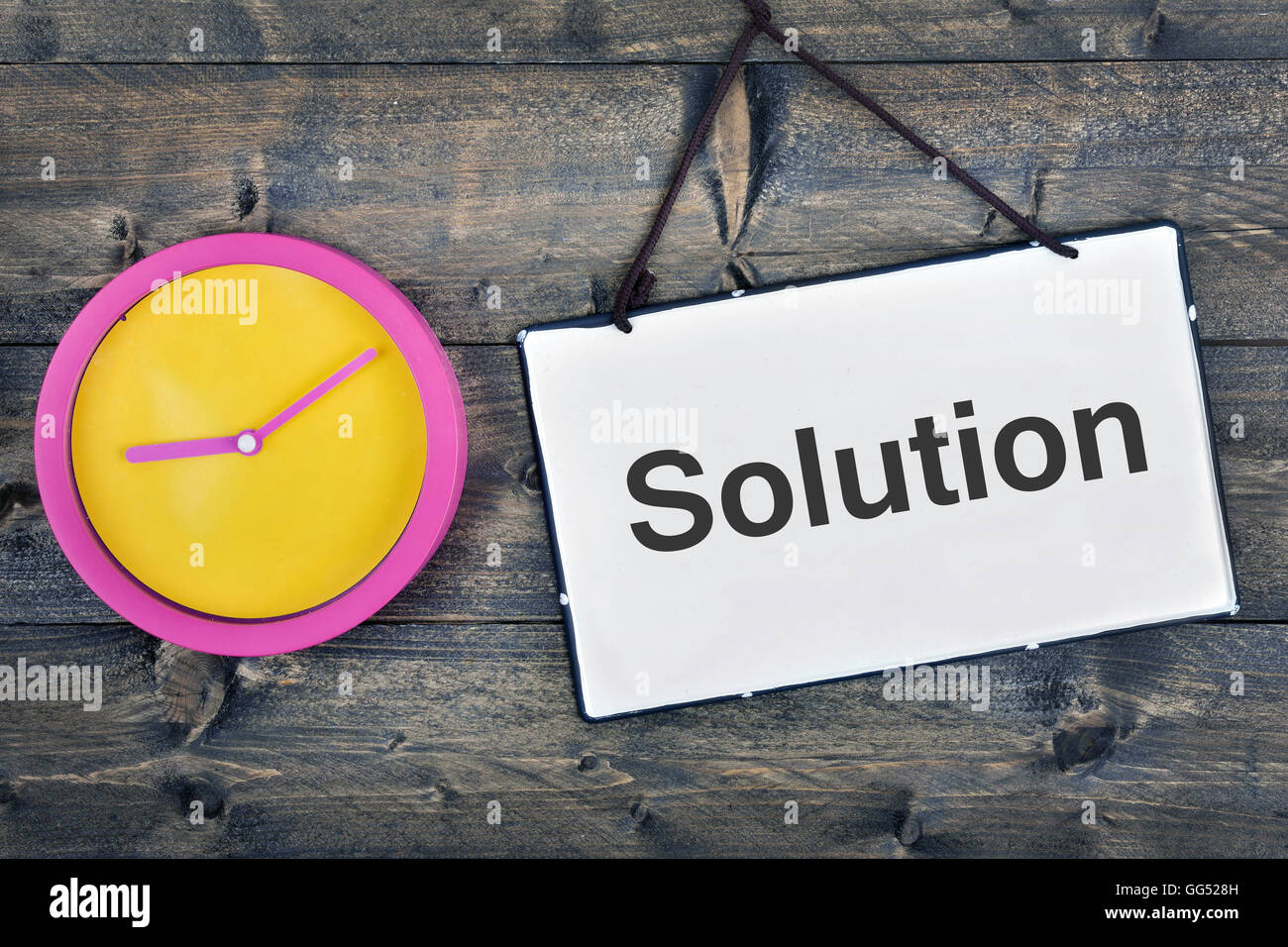Solution sign and clock on wooden table Stock Photo - Alamy