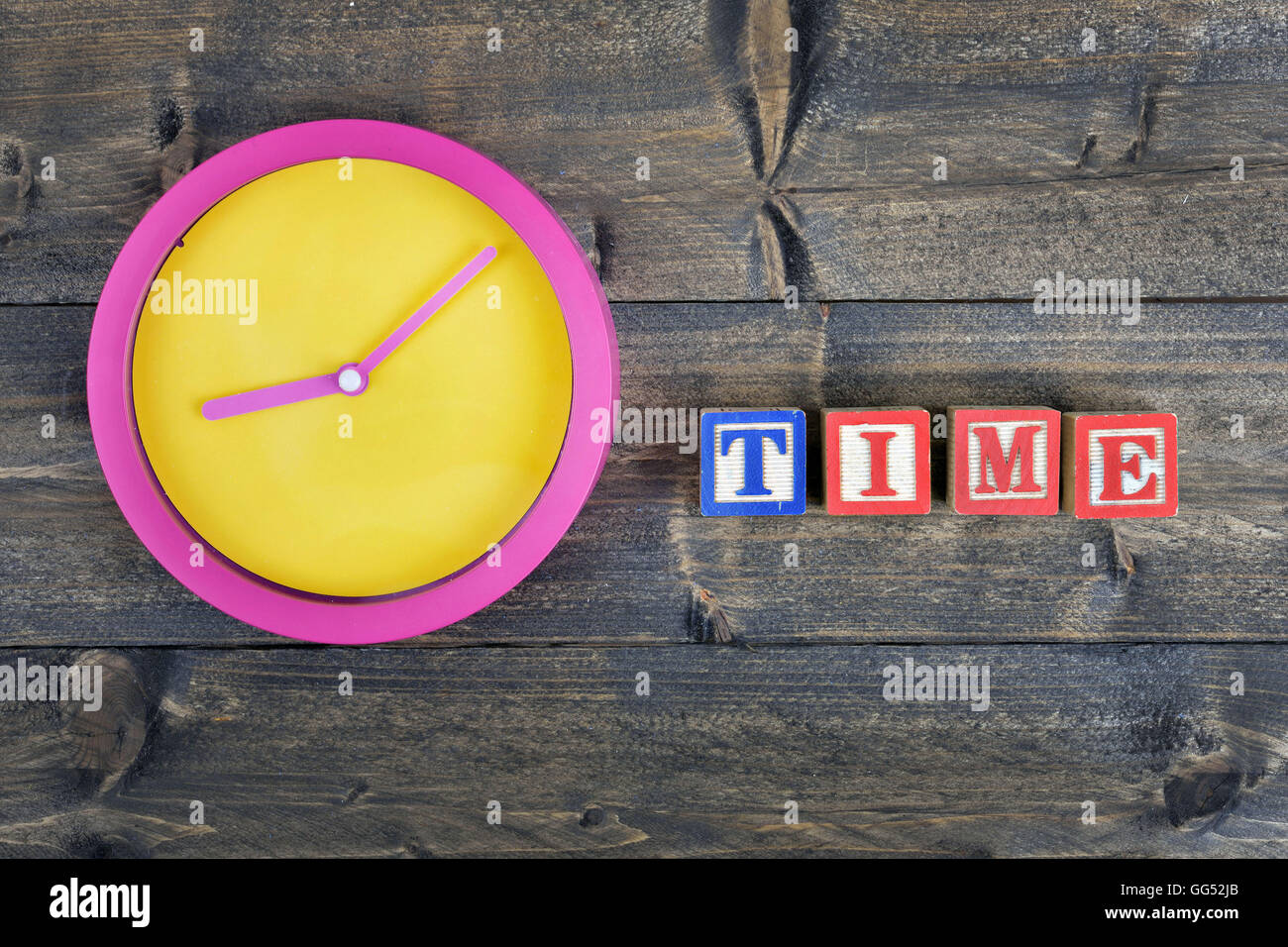 Clock and word Time on wooden table Stock Photo - Alamy