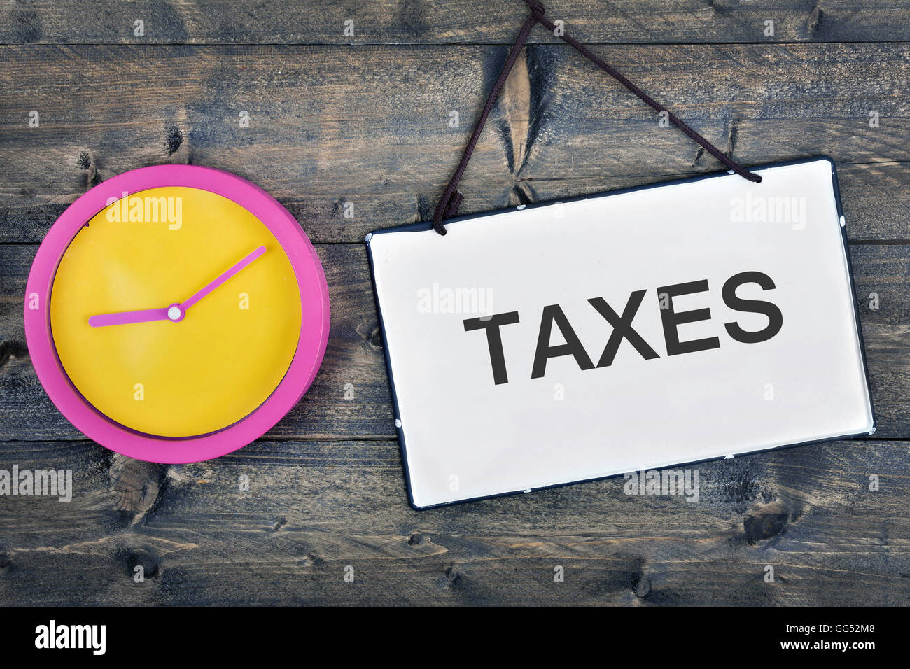 Taxes sign and clock on wooden table Stock Photo - Alamy