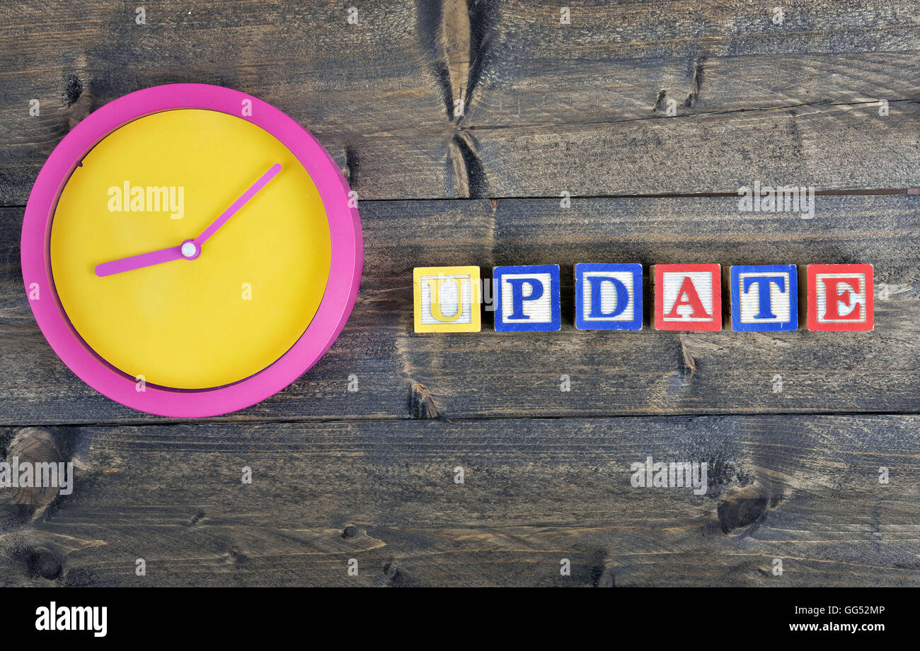 Clock and word Update on wooden table Stock Photo - Alamy