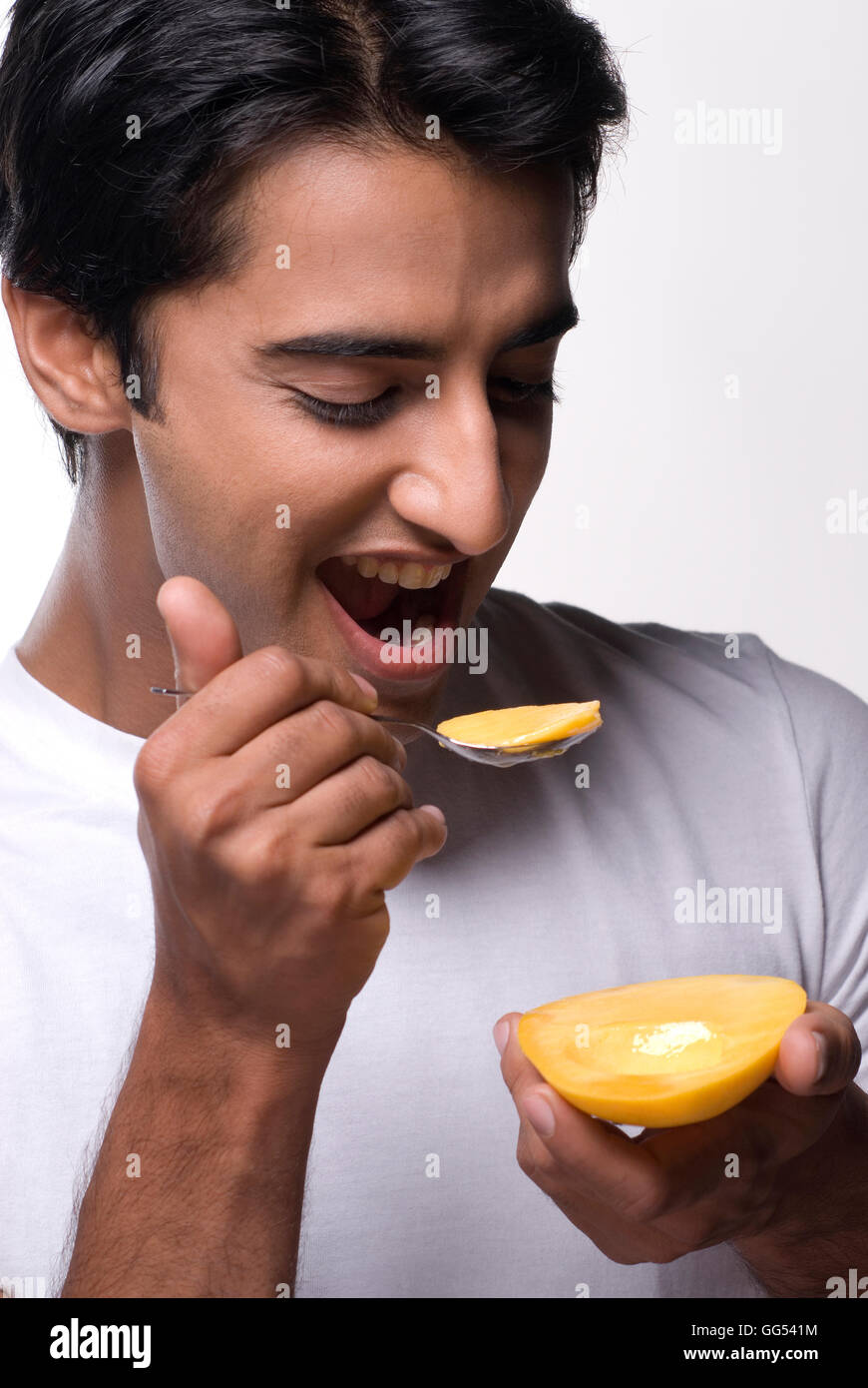 Man eating a mango Stock Photo - Alamy