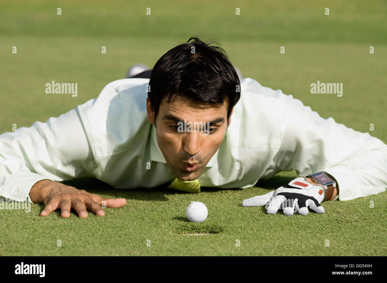 Man looking at golf ball Stock Photo - Alamy