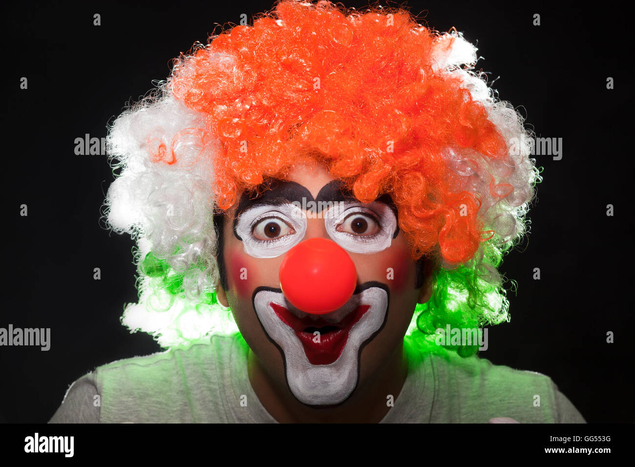 Surprised male clown over black background Stock Photo - Alamy