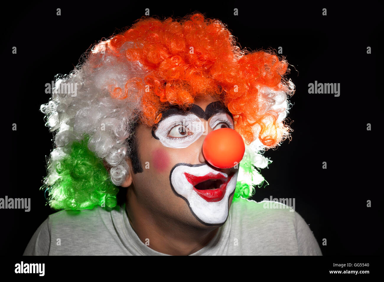 Surprise male clown over black background Stock Photo - Alamy