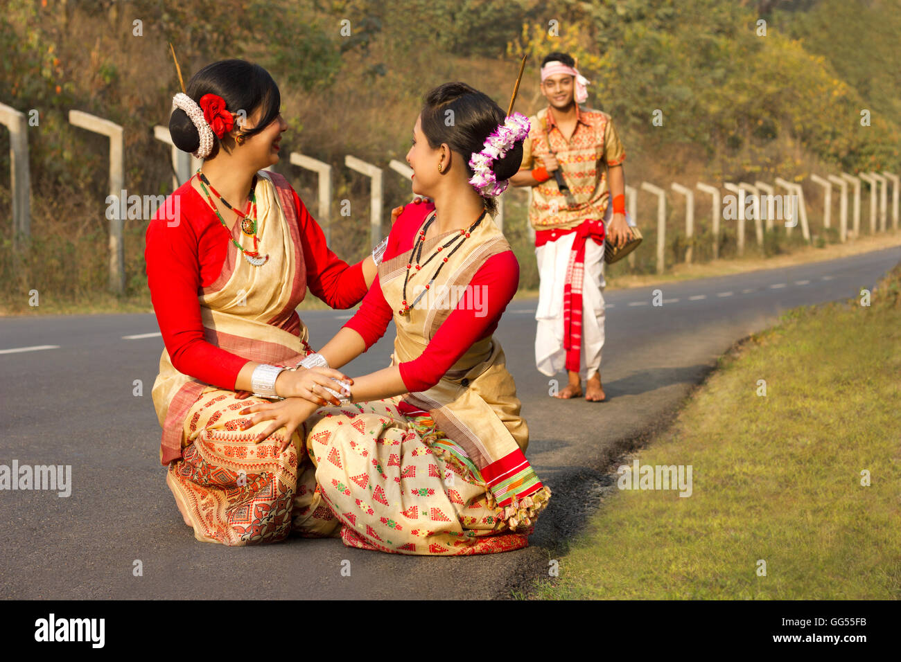 Bihu dancers squatting as Bihu man walks up Stock Photo - Alamy