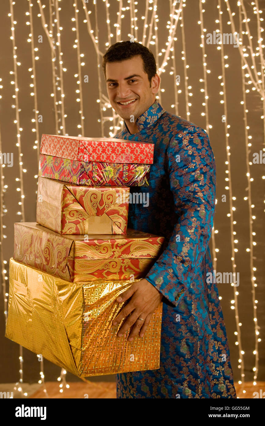 Indian man holding presents Stock Photo - Alamy