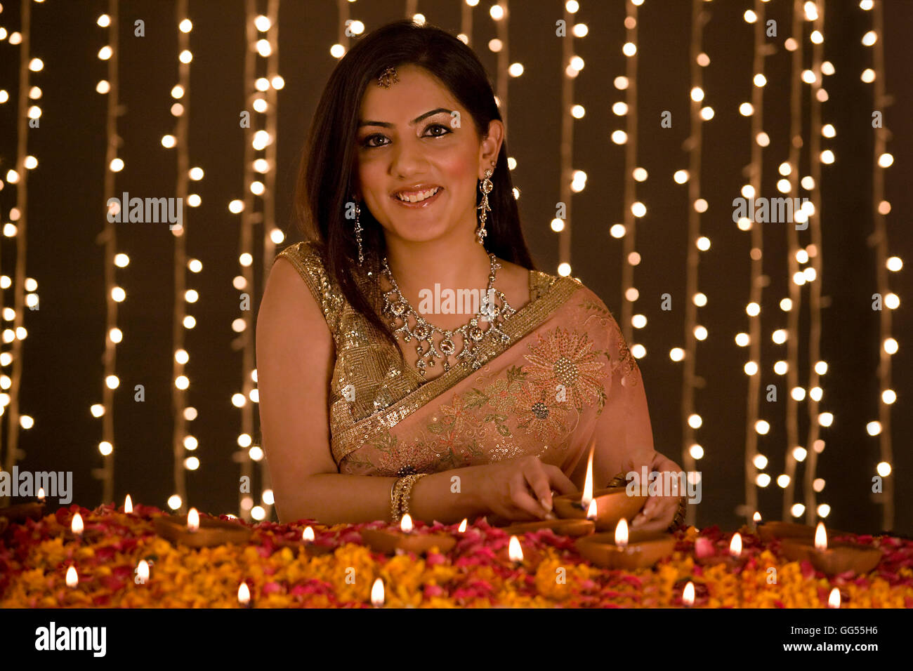 Woman lighting diyas Stock Photo - Alamy