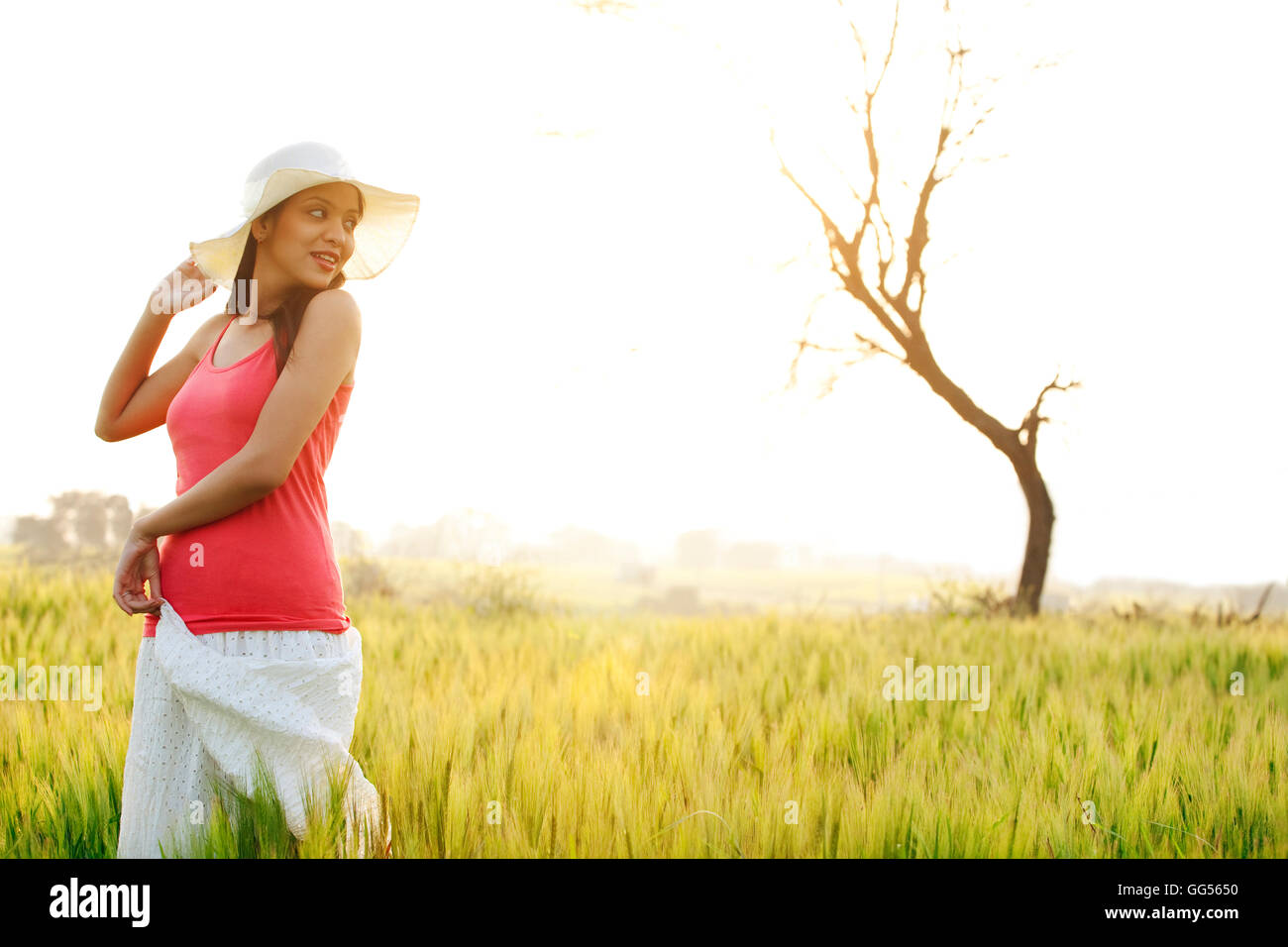 Woman standing in a field Stock Photo - Alamy
