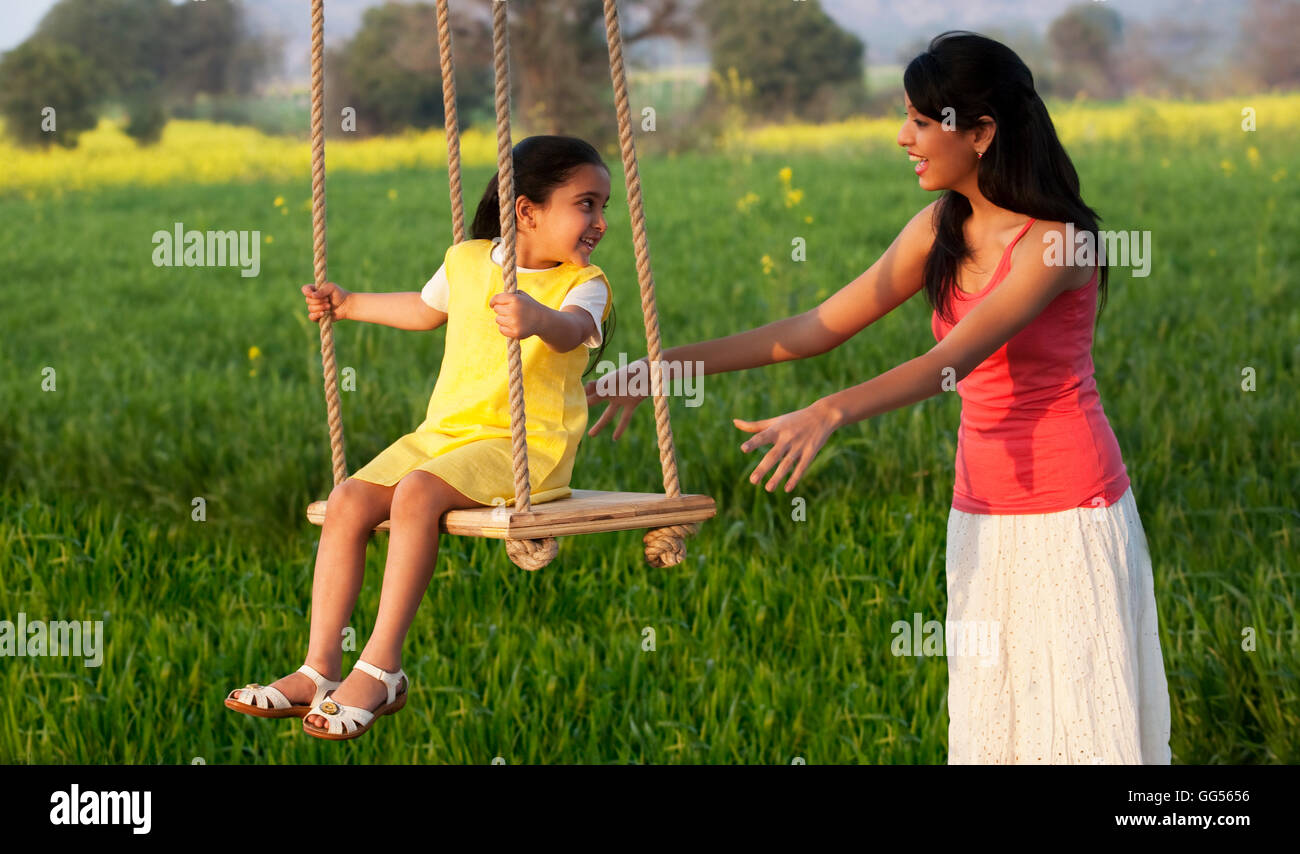 Mother swinging her daughter Stock Photo - Alamy