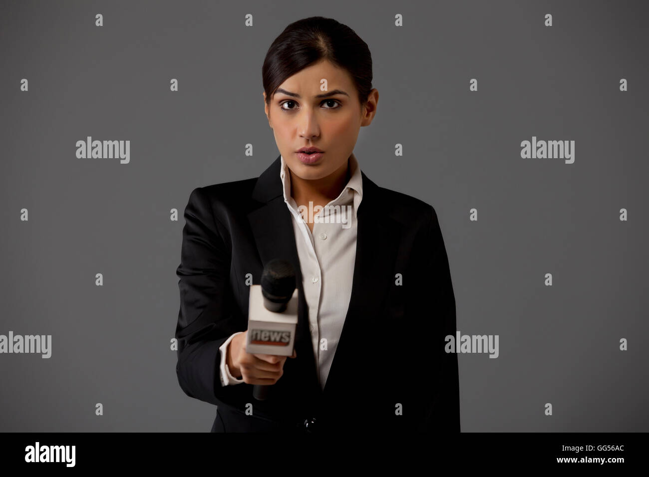 Portrait of woman reporter asking against colored background Stock ...