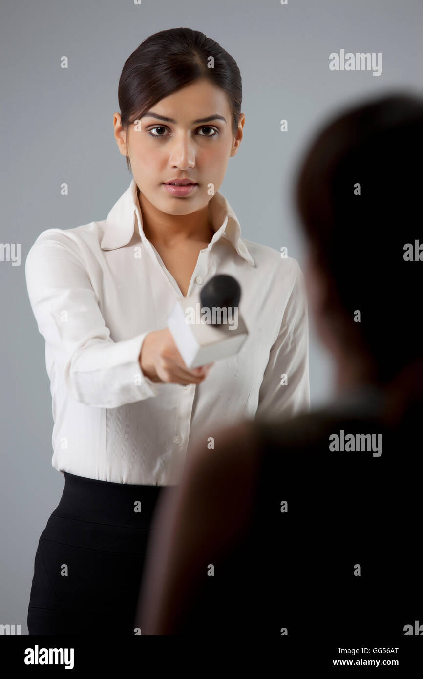 Young female reporter taking interview of a person Stock Photo - Alamy