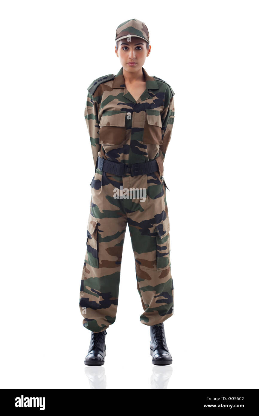 Full length of a young female soldier standing against white background ...