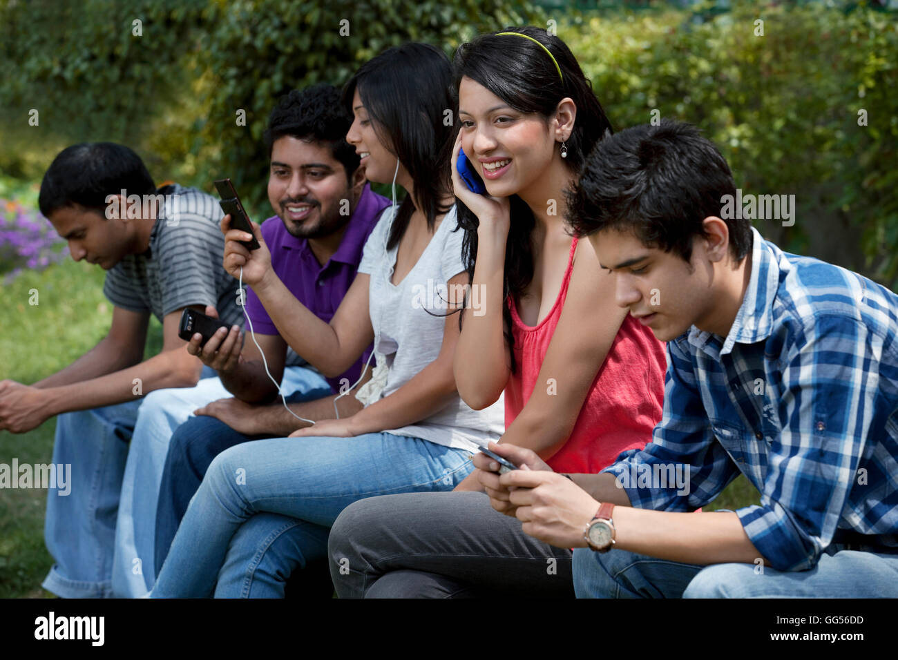 Group of young friends busy with their mobile phones Stock Photo - Alamy