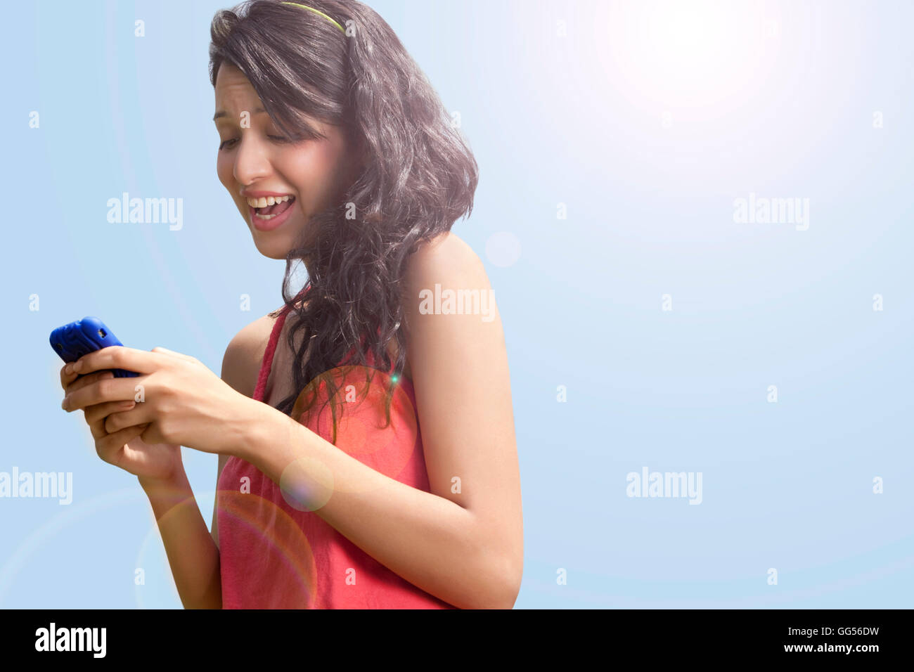 Cheerful young woman text messaging Stock Photo - Alamy