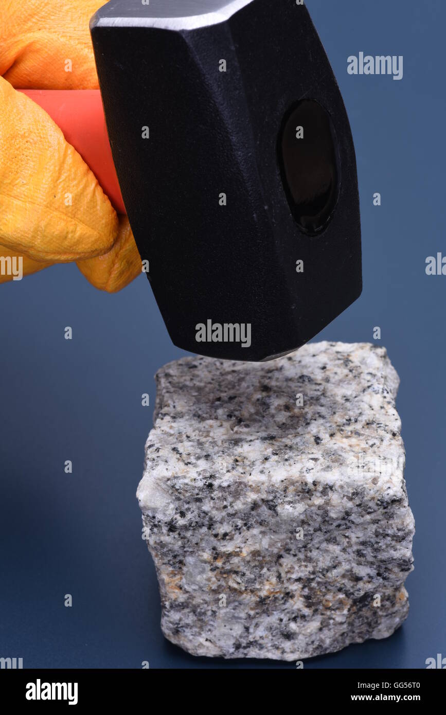 Close-up of hand holding hammer and stone block Stock Photo - Alamy
