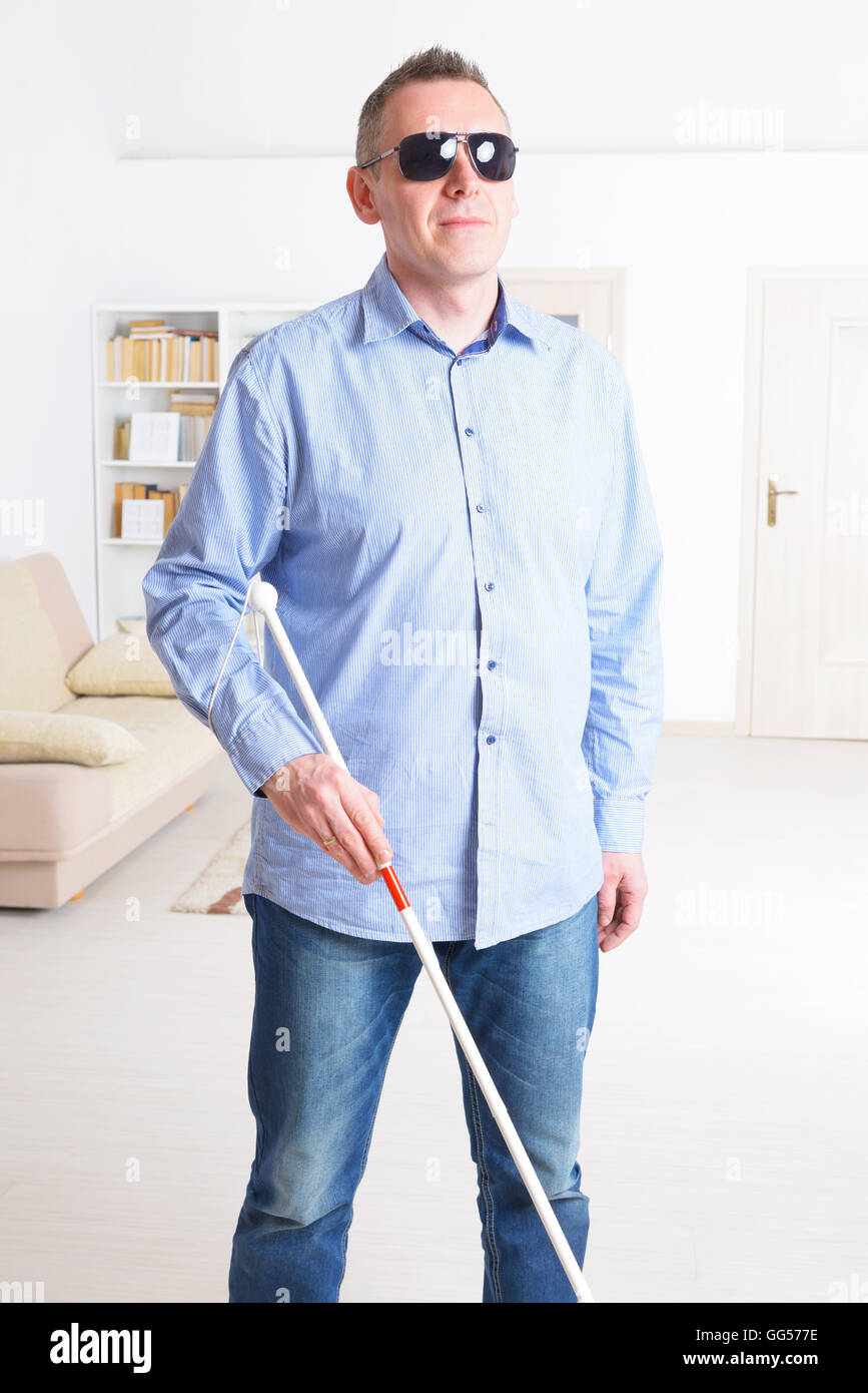 Blind man with white stick and dark glasses at home Stock Photo - Alamy